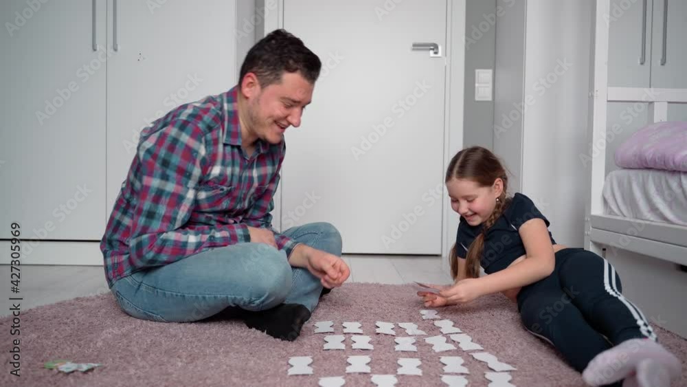 Father and daughter are playing in the bright children's room. The game ...