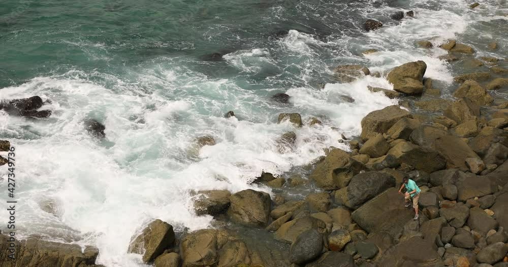 Woman rocky tropical beach ocean waves Ghana. Southernmost tip of Ghana ...