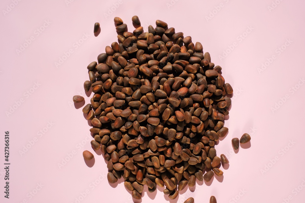Pine nuts heap on a pink background. Nuts and seeds. Siberian cedar ...