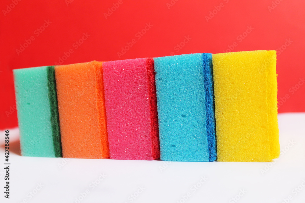 Five scouring sponges on a red and white background, side view. New ...