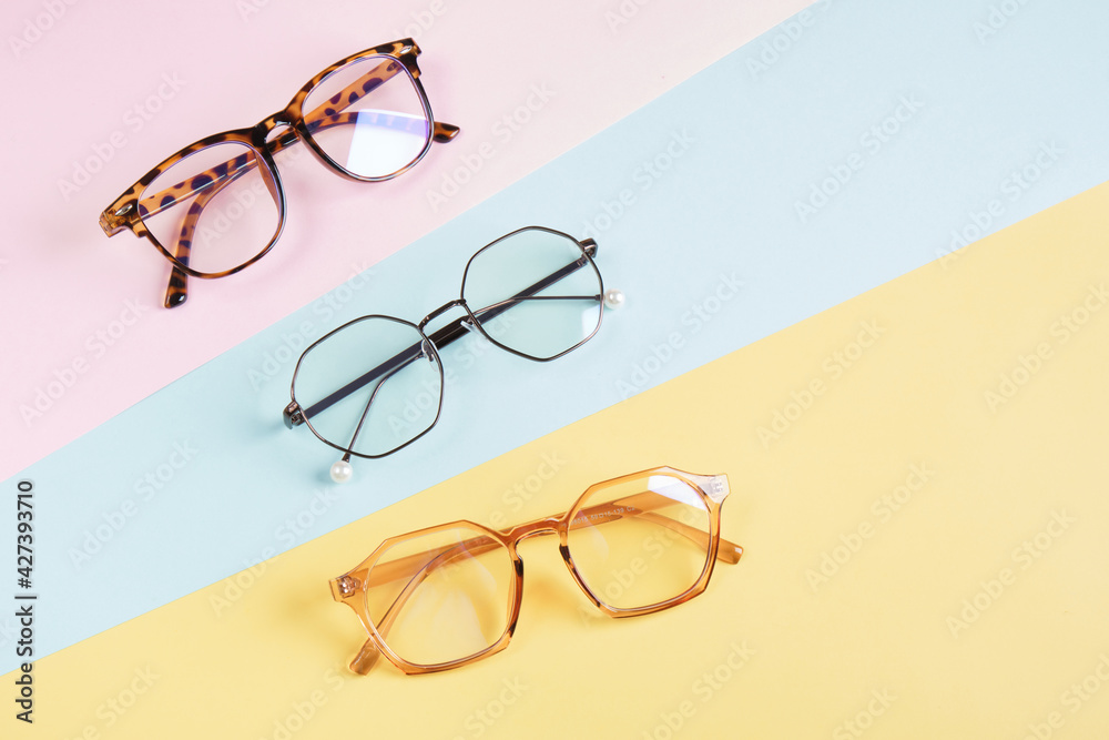 multiple eyeglasses on a multicolored background of pastel colors ...