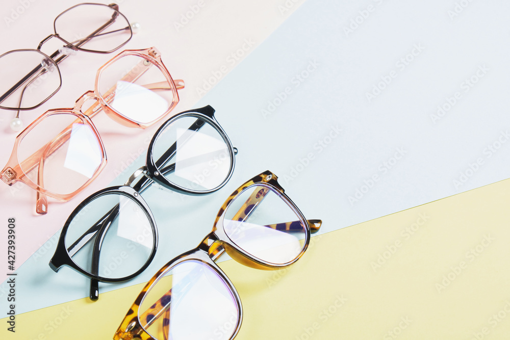multiple eyeglasses on a multicolored background of pastel colors ...