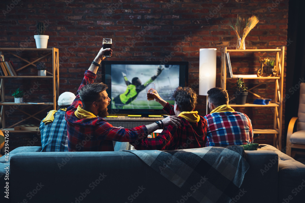 Foto de Group of friends watching TV, sport match together. Emotional ...