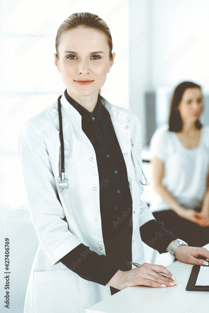 Woman-doctor at work with colleague and patient at background. Middle ...