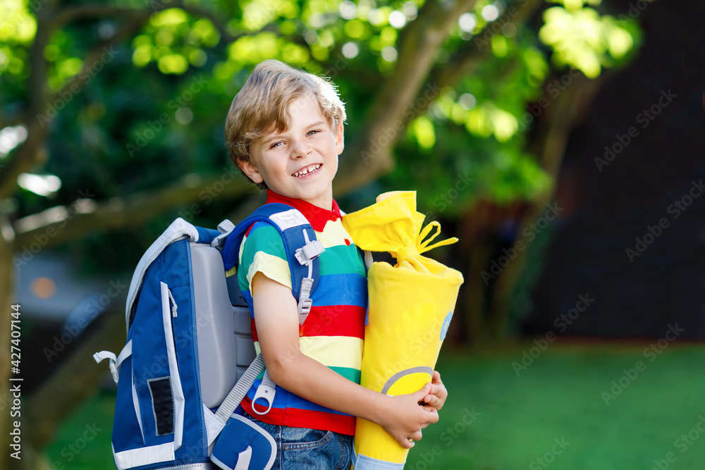 Happy little kid boy in colorful shirt and backpack or satchel and ...