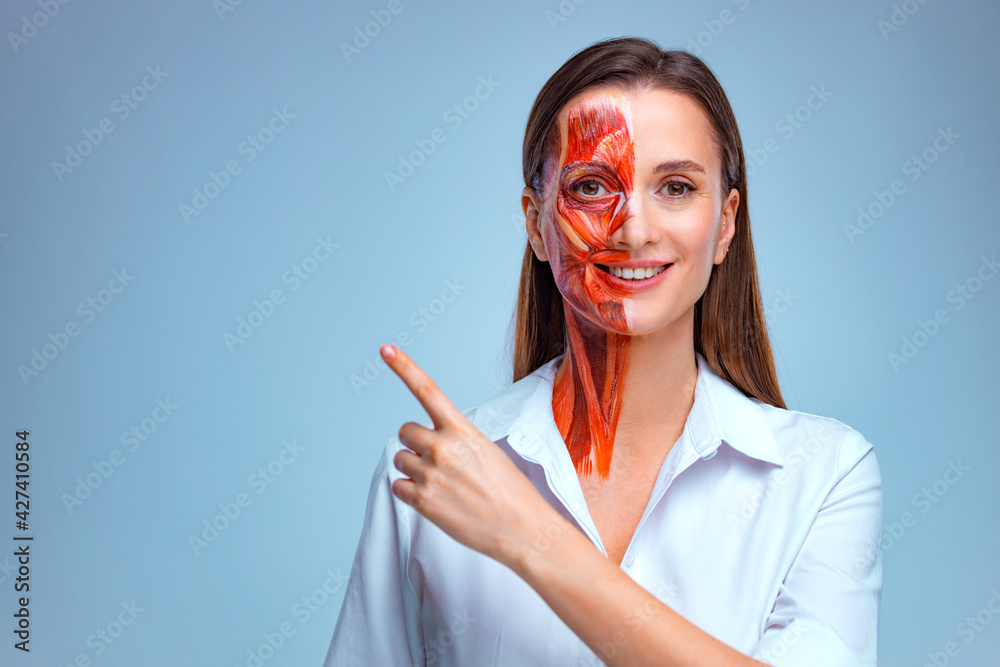 Young woman with half of face with muscles structure under skin ...