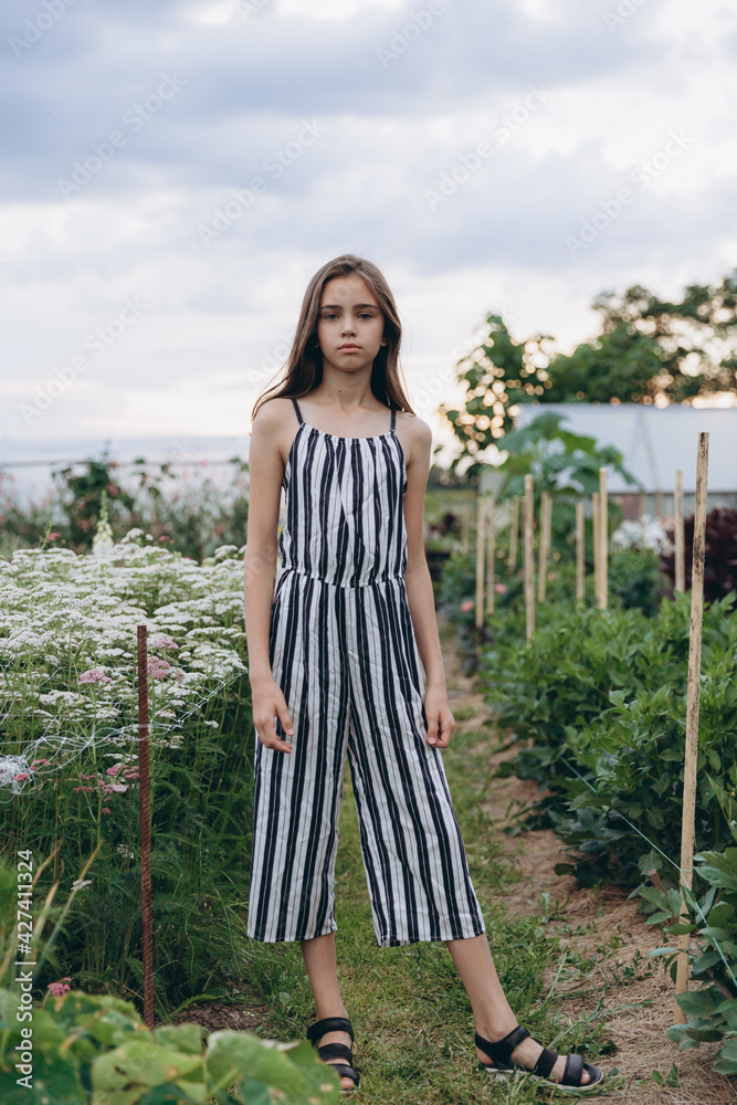Cute 13-year-old child girl carrying basket of beautiful flower in the ...