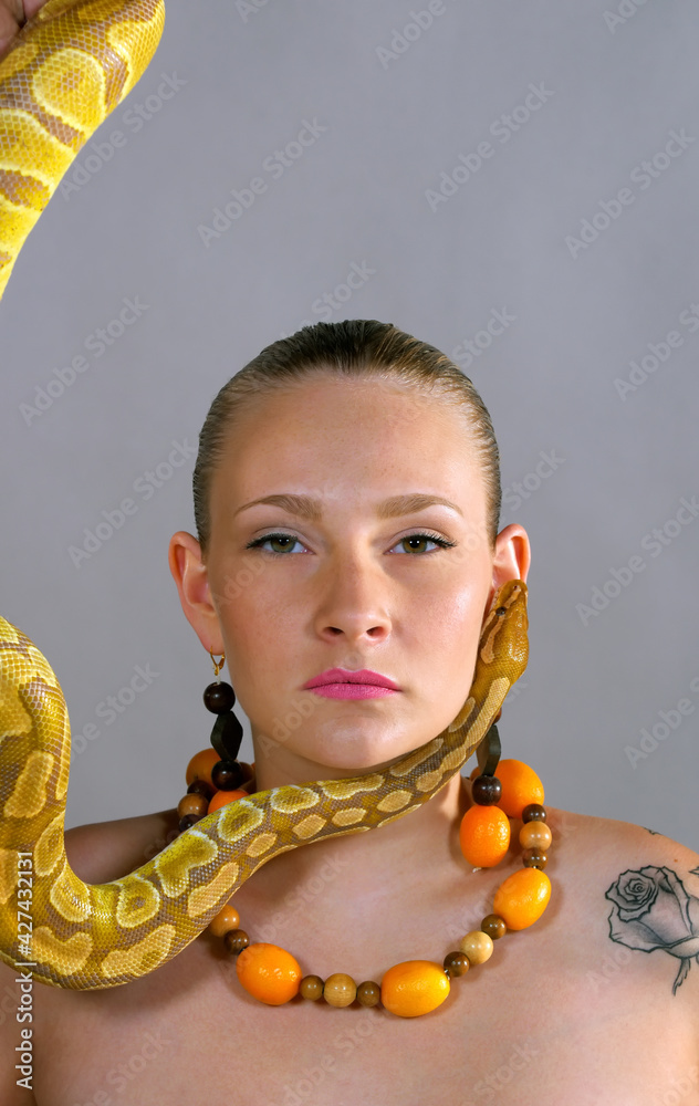 A beautiful young model poses nude for the camera. Her earrings and ...