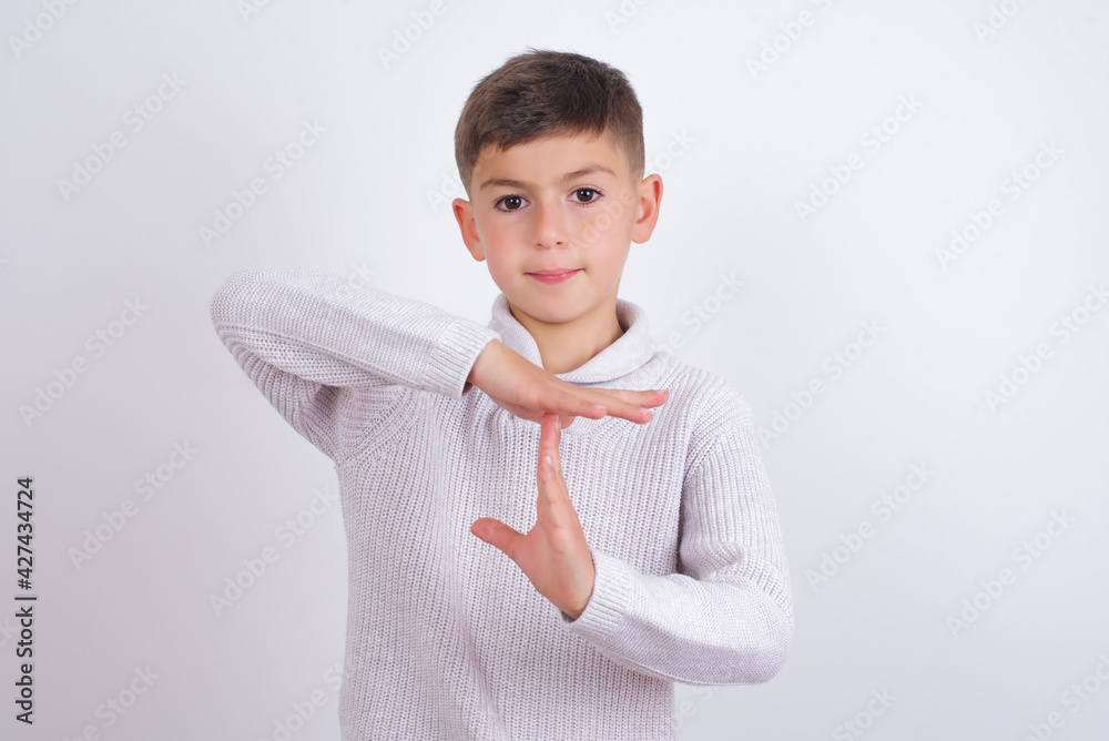 Caucasian kid boy wearing knitted sweater against white wall being ...