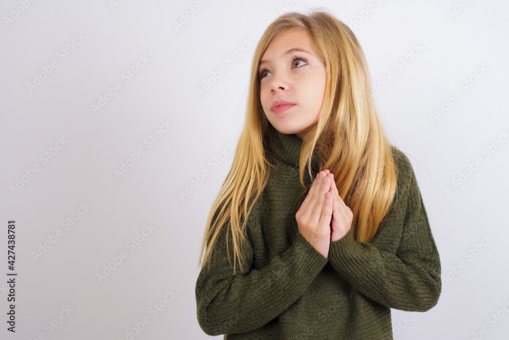 Charming cheerful Caucasian kid girl wearing green knitted sweater ...