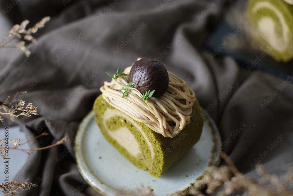 Green Tea Swiss Roll Cake with Chestnut cream filling set on cafe table ...