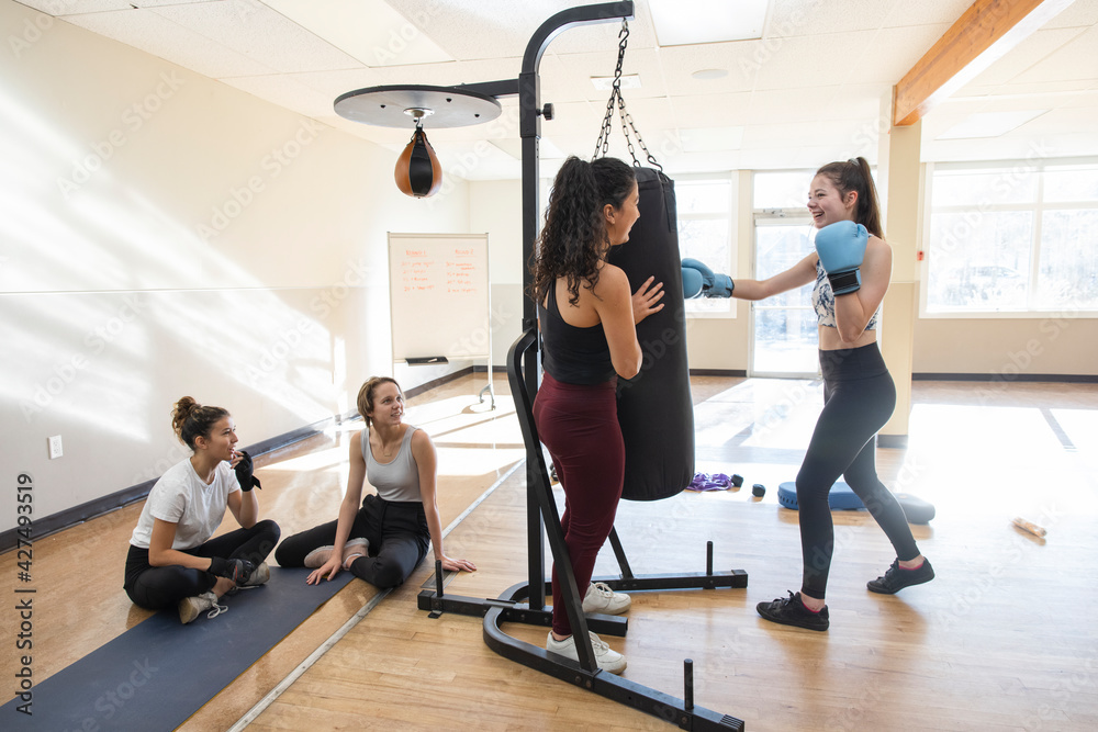 Teen girls boxing at punching bag in gym studio Stock Photo | Adobe Stock