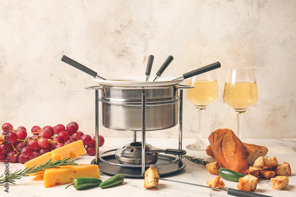 Cheese fondue and different snacks on light background Stock Photo ...