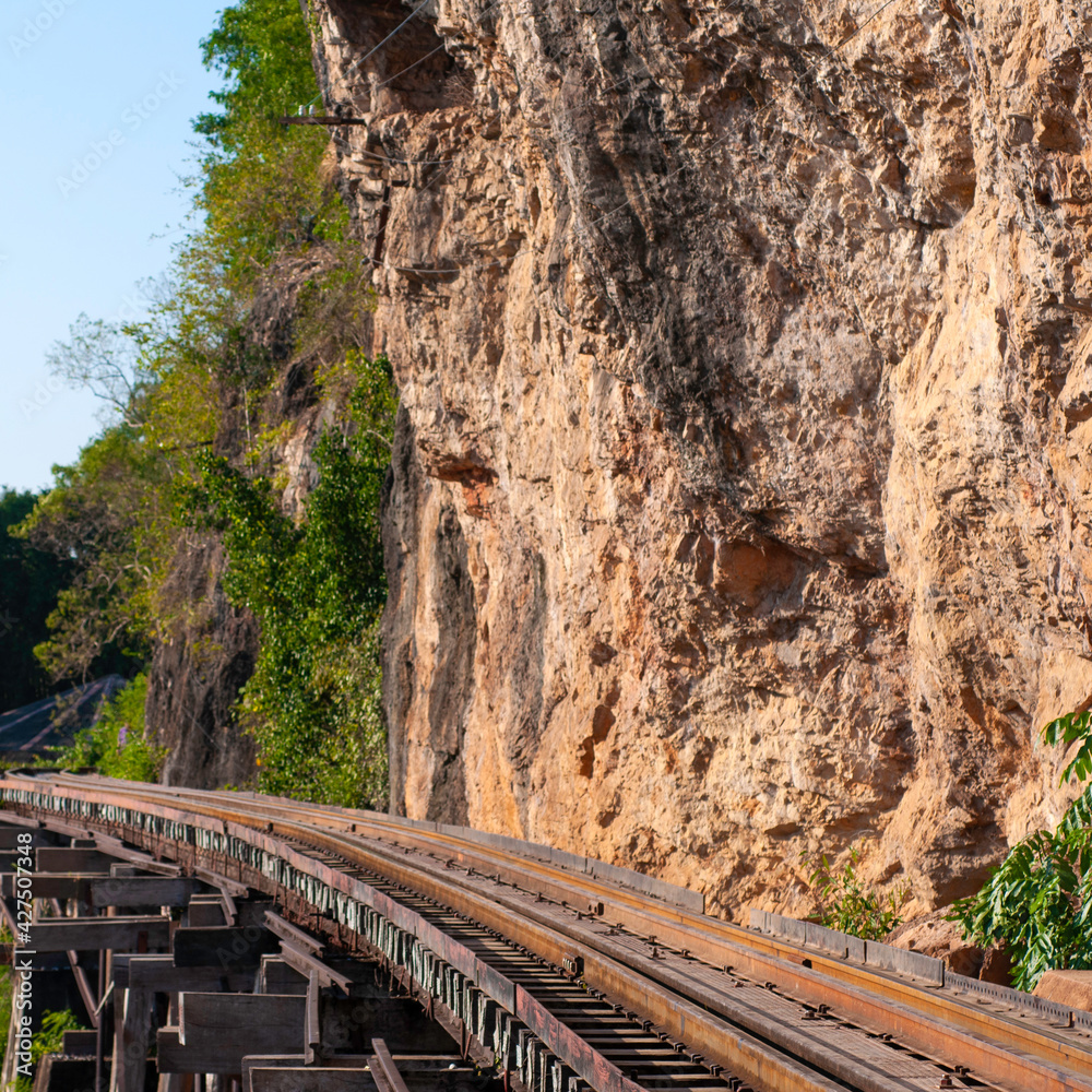 Vintage locomotives train on track running through mountain cliff ...