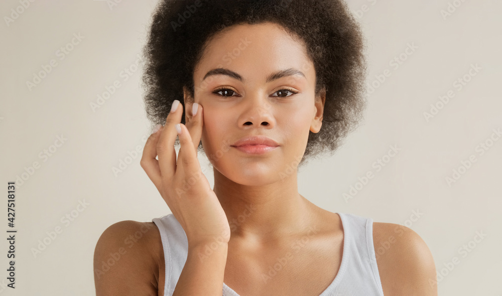 Black african american woman applying moisturizing cream on her face ...