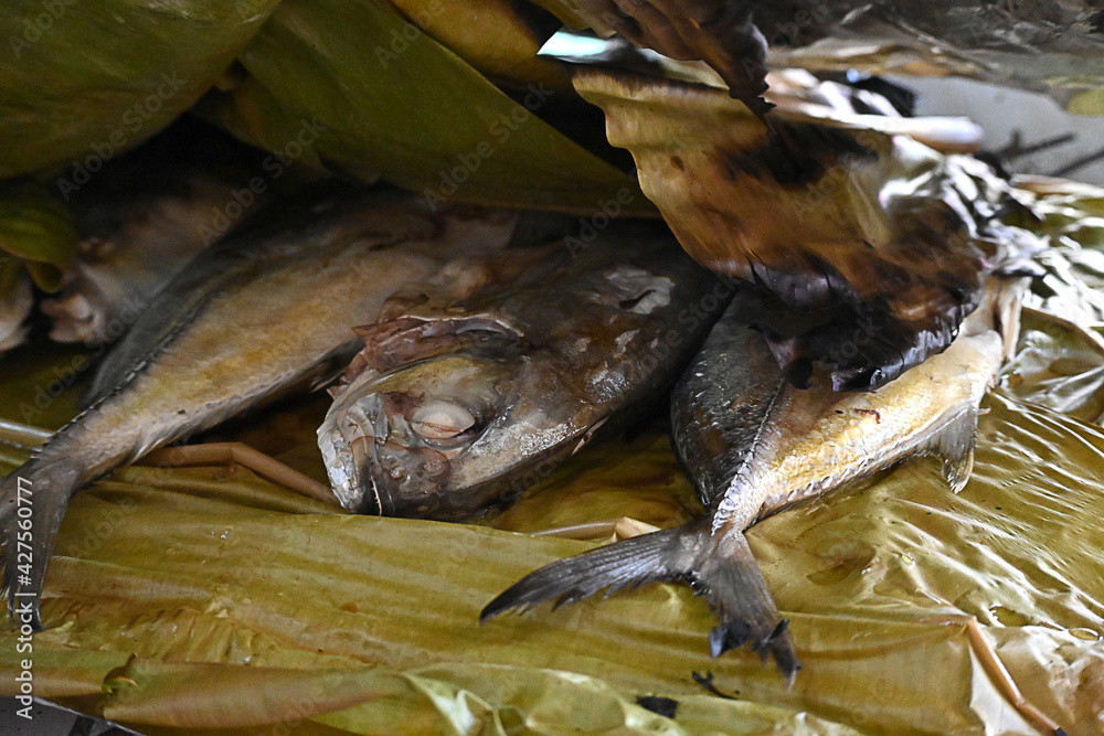 A delicious traditional grilled fish on a banana leaf by using a ...