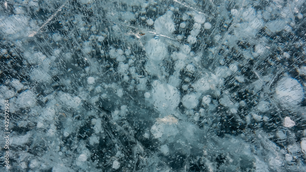 Transparent ice of Lake Baikal, close-up. Cracks are visible on the ...