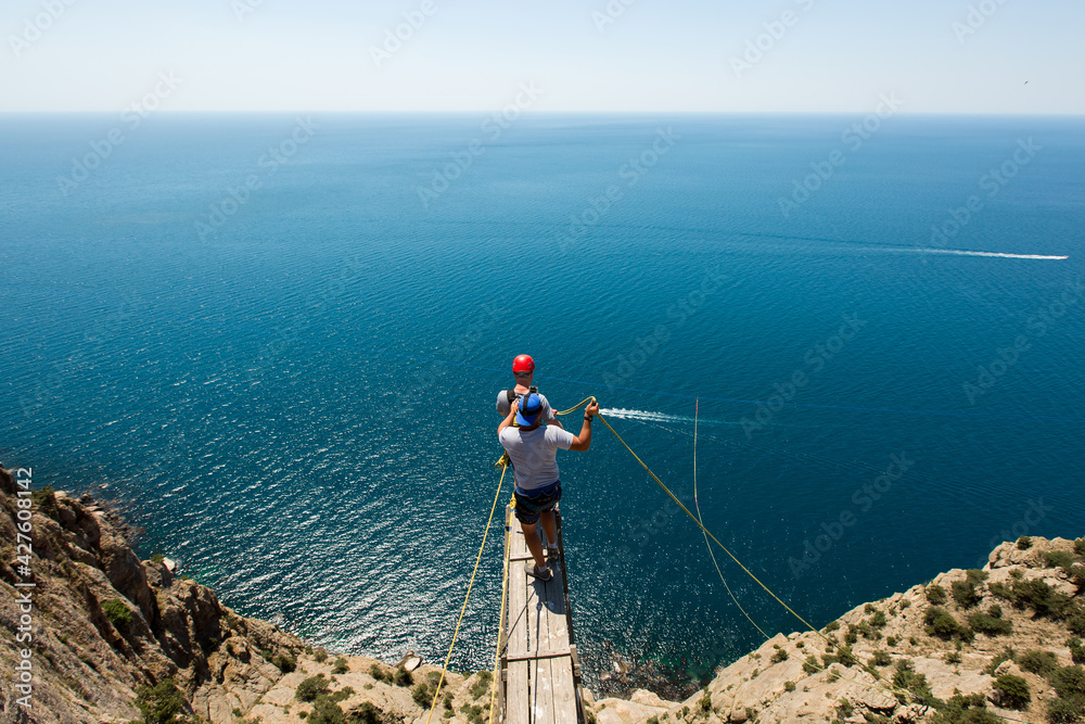 Rope jumping off a cliff with a rope in the water. The ocean. Sea ...