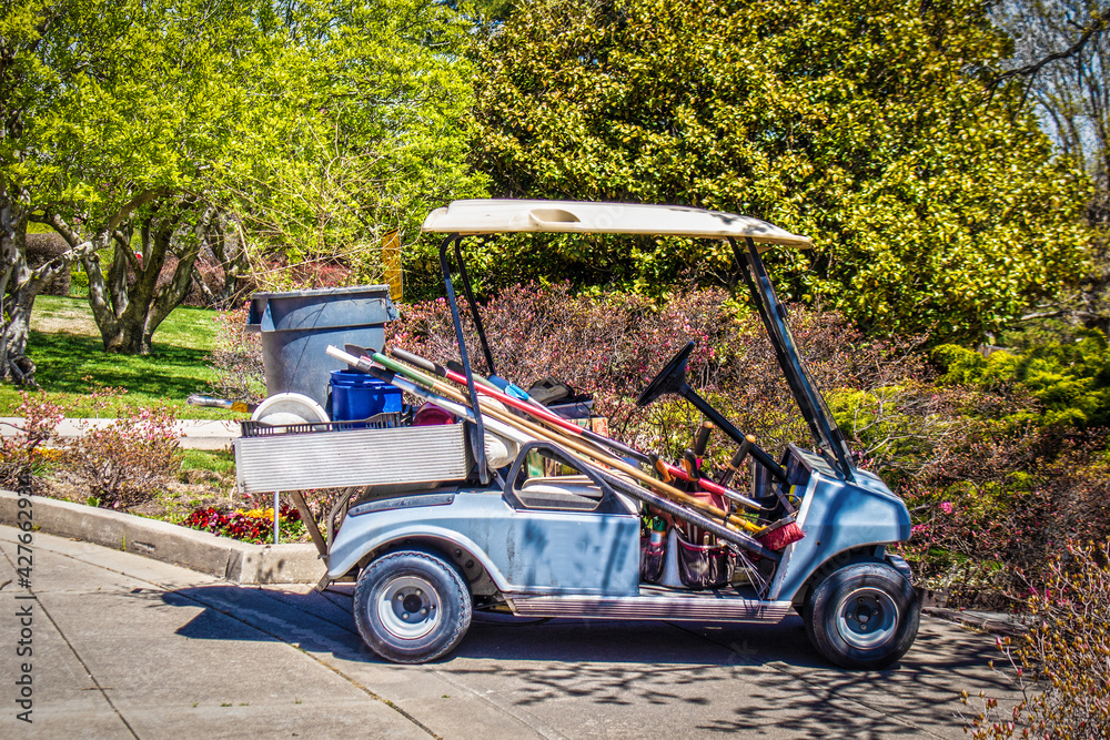 Motorized golf cart being used as a garden maintenance vehicle parked ...