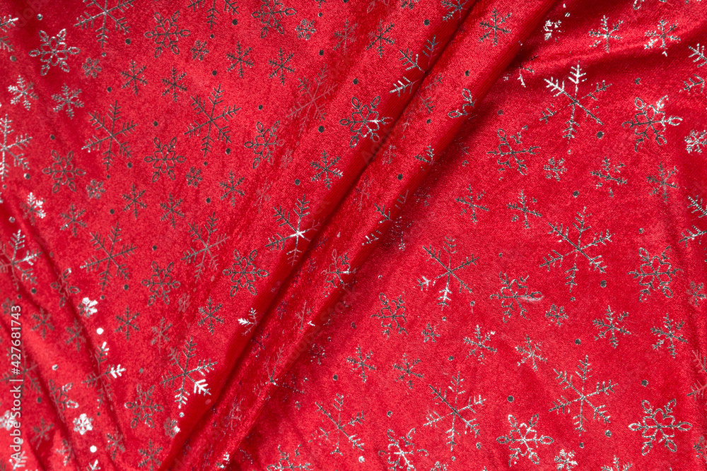 Colored red textile satin fabric folded in folds and waves with ...