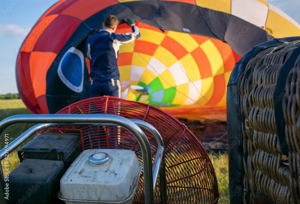 Preparing the balloon for flight. A man fills a balloon with gas ...