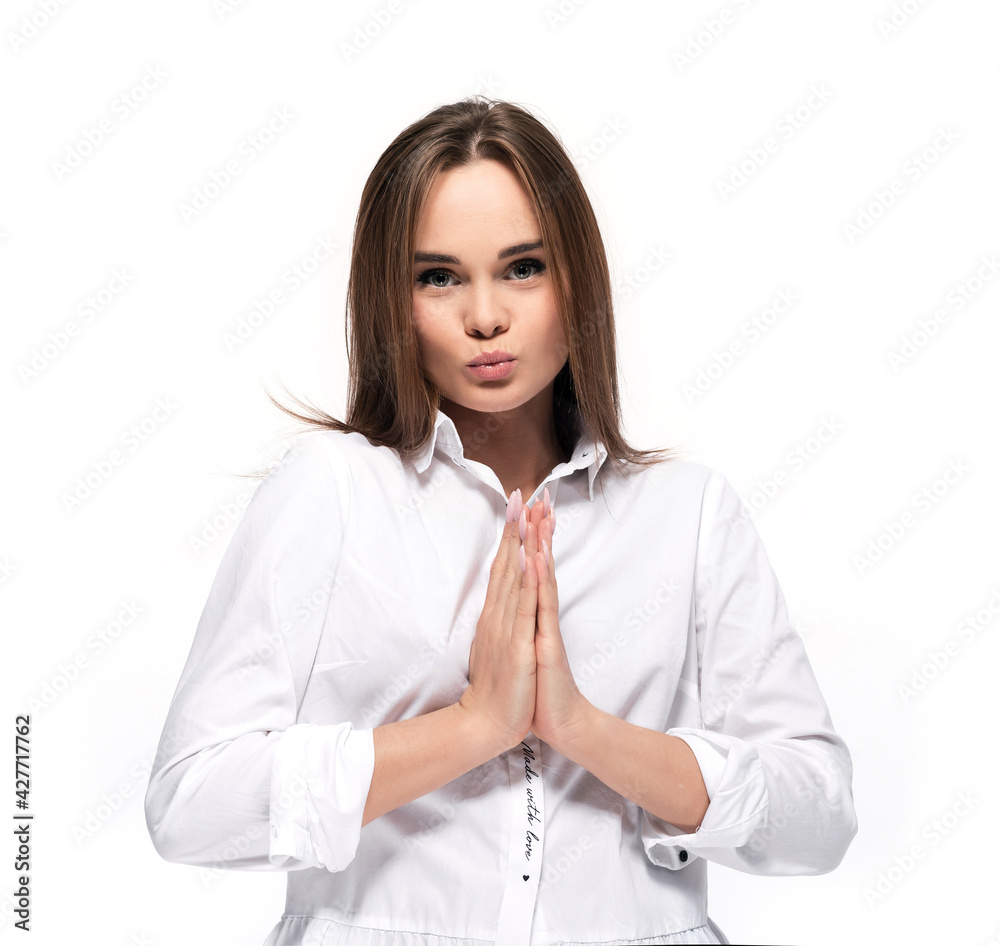 Beautiful young woman shows a begging thank you sign against white wall ...
