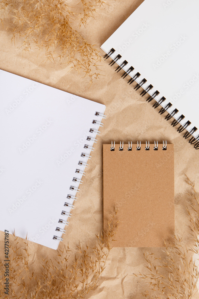 blank notebooks with white paper and dry pampas grass on crumpled brown ...