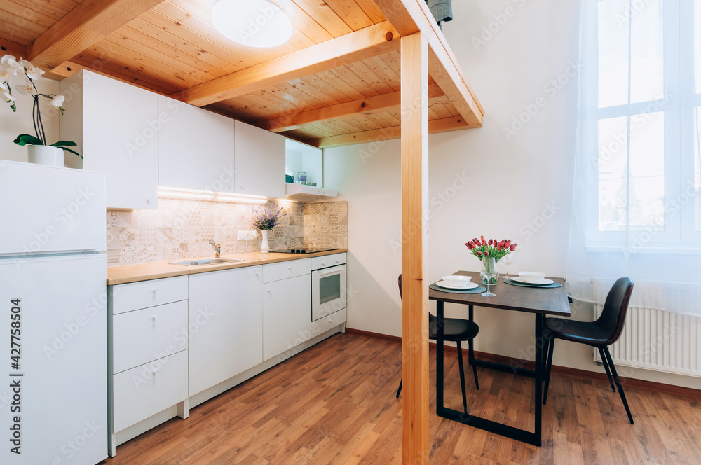 Loft apartment with kitchen, which is under wooden construction forming ...