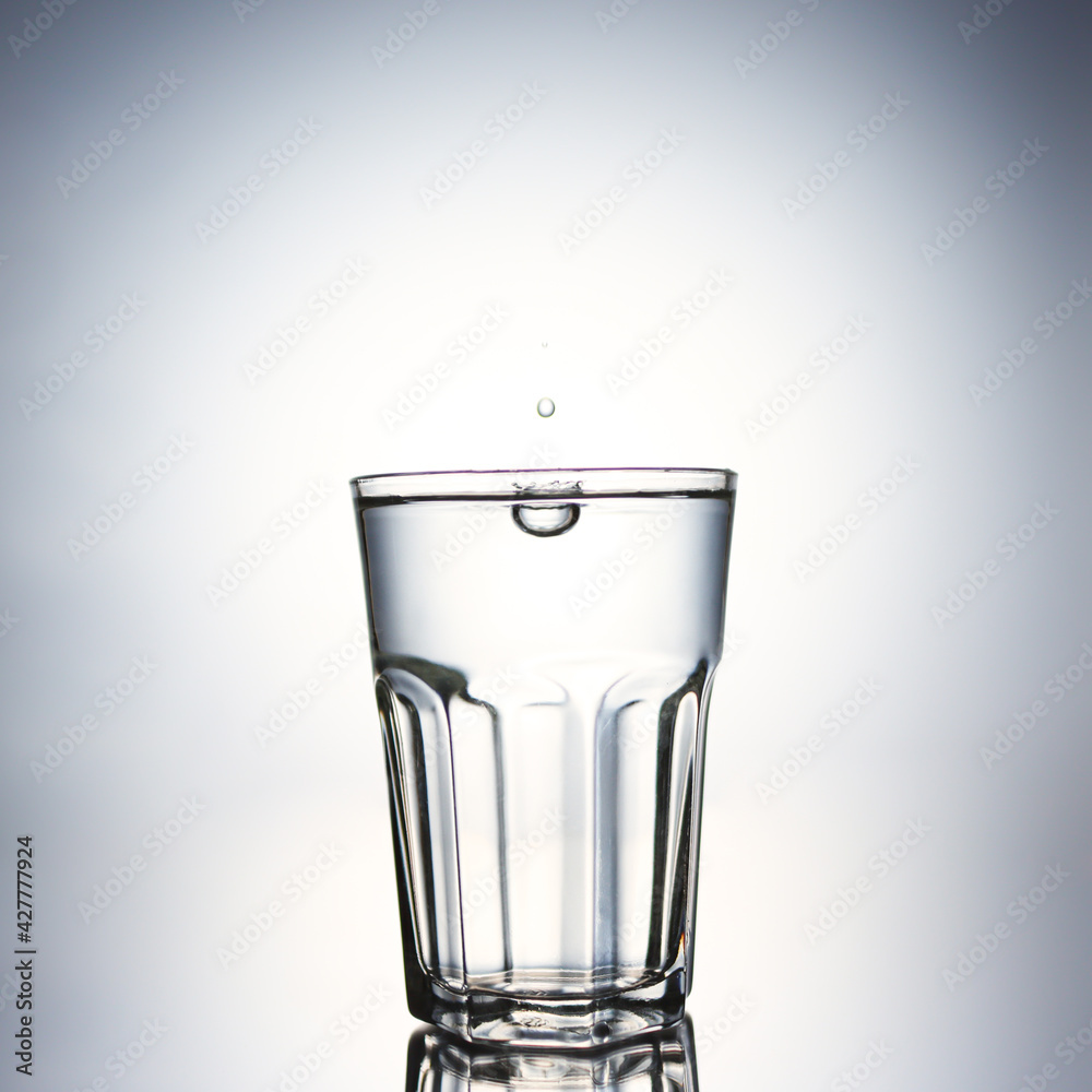 Water drops Falling Into Glass Cup Stock Photo | Adobe Stock