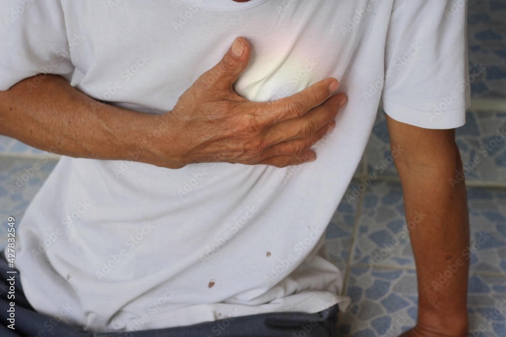 Old Asian Man clutching his chest from acute pain in sitting position ...