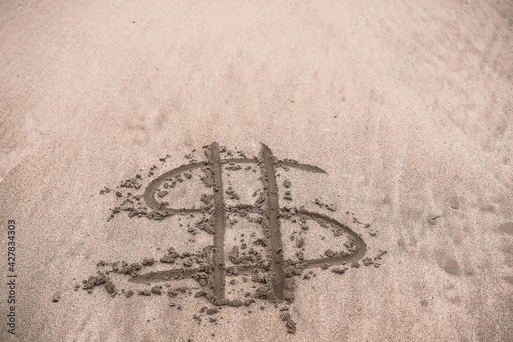United States of America dollar sign hand drawing on a sand on a beach ...