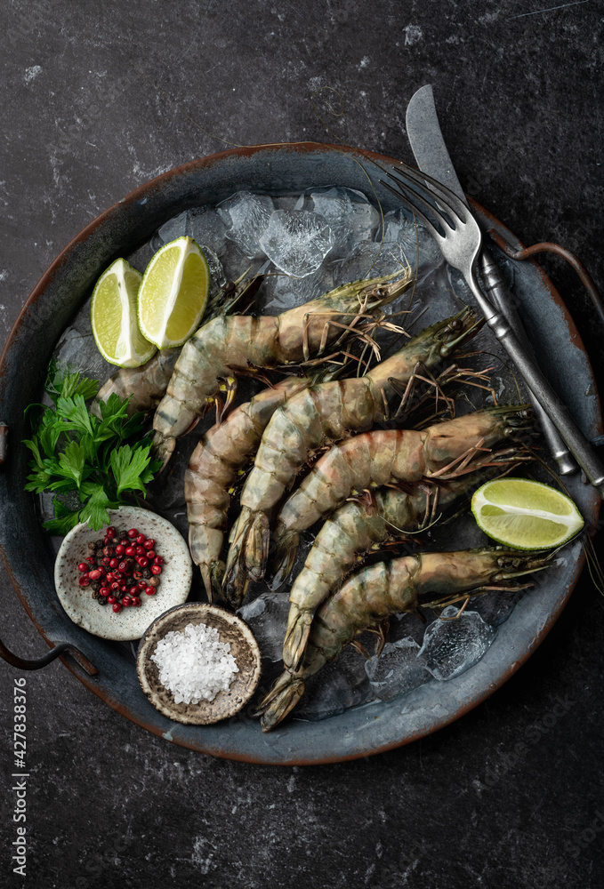 raw black tiger prawns on ice on a concrete background, top view ...