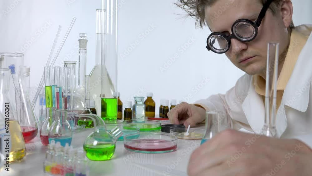 funny scientist between flasks and reagents. laboratory assistant in ...