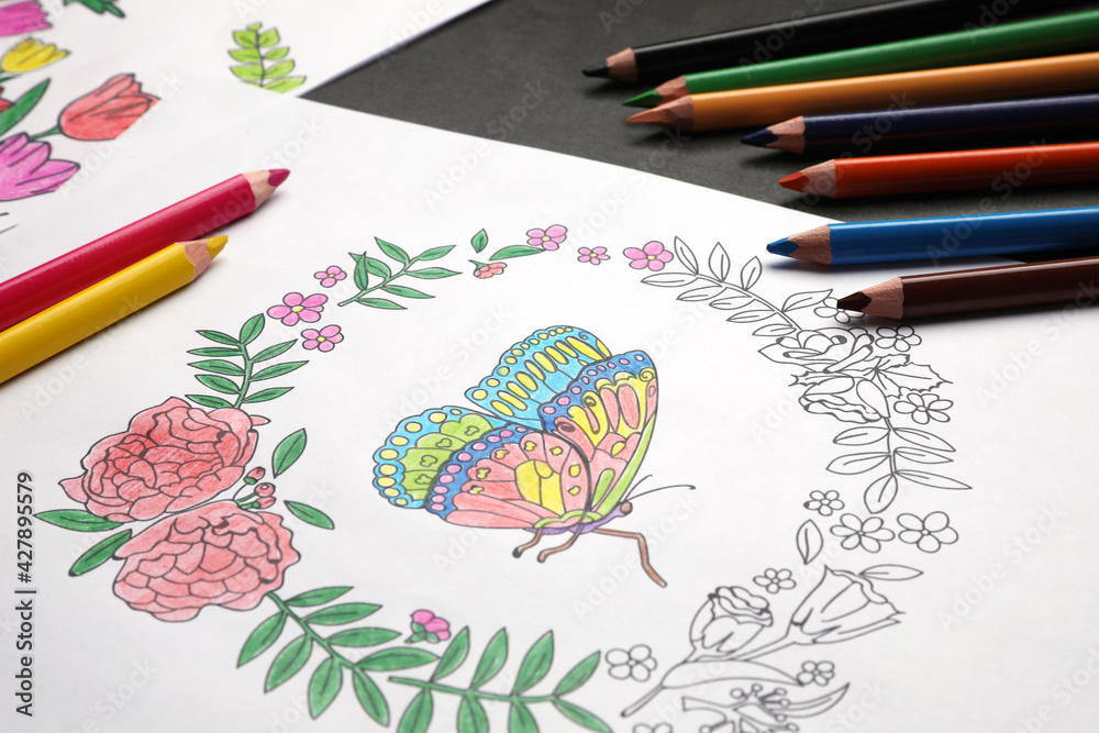 Coloring page with children drawing and set of pencils on grey table ...