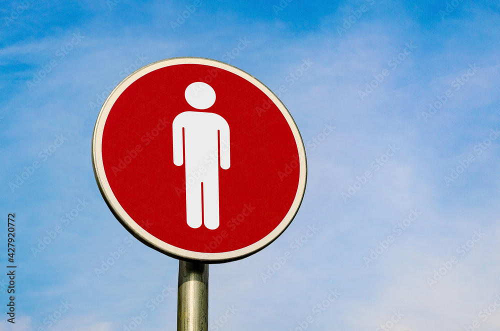 Red circular road sign with man pictogram. Blue sky background. Stock ...