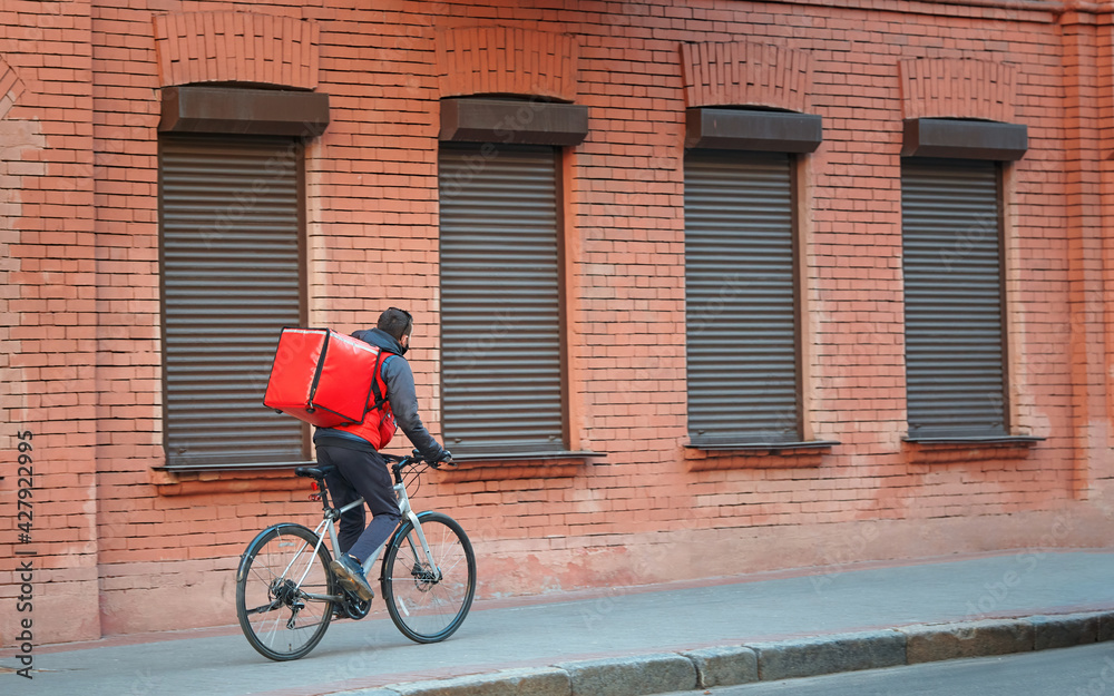 Courier with red thermal backpack on bicycle delivering pizza. Delivery ...