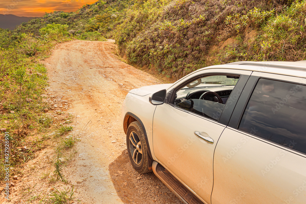 SUV car going up the sierra on a rocky road, white car on sloping ...