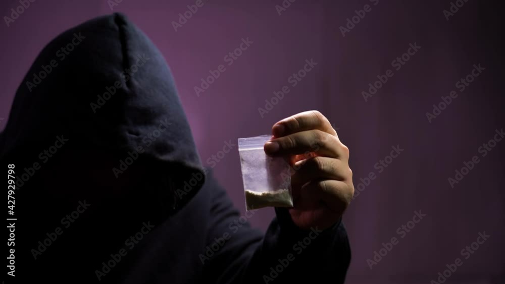 a drug dealer offers the drug in a dark place. drug trafficking concept ...