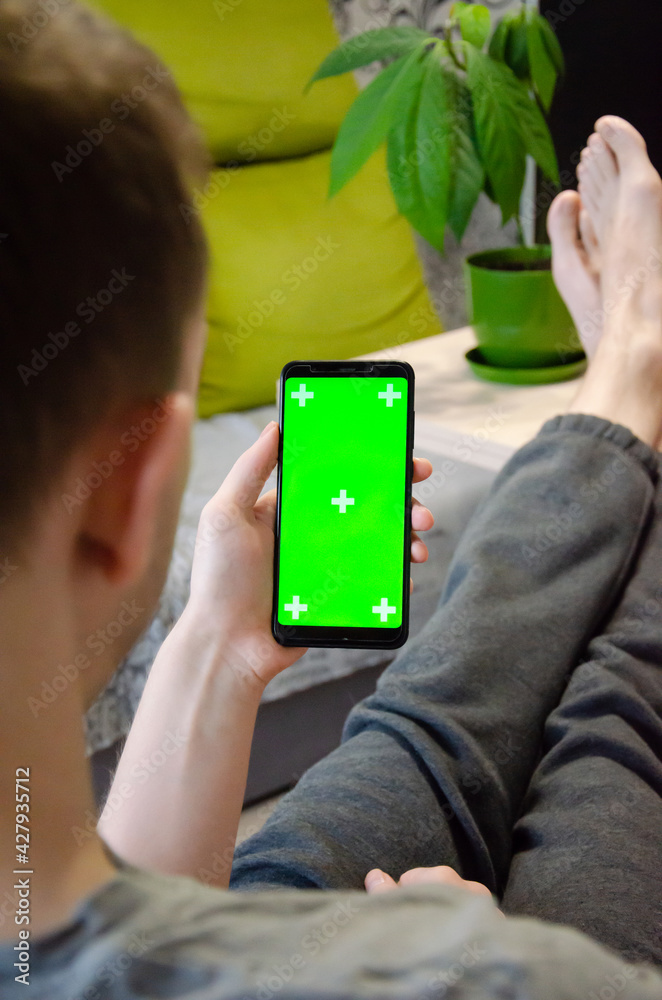 Green screen and chroma key. Caucasian man holding mobile phone with ...