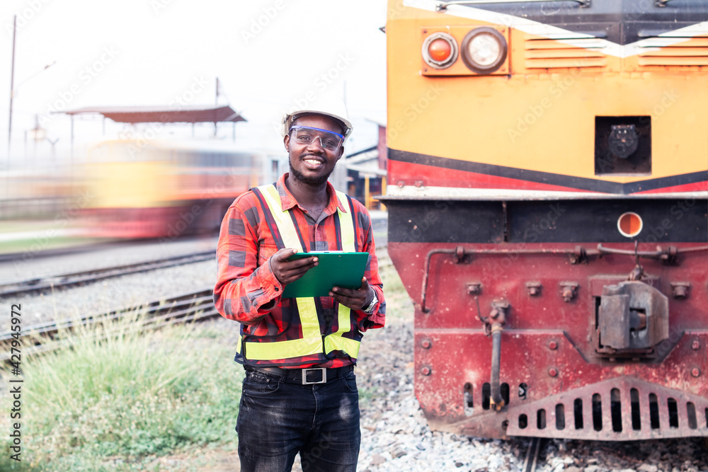 African man engineer looking report of Train Timetables for control a ...