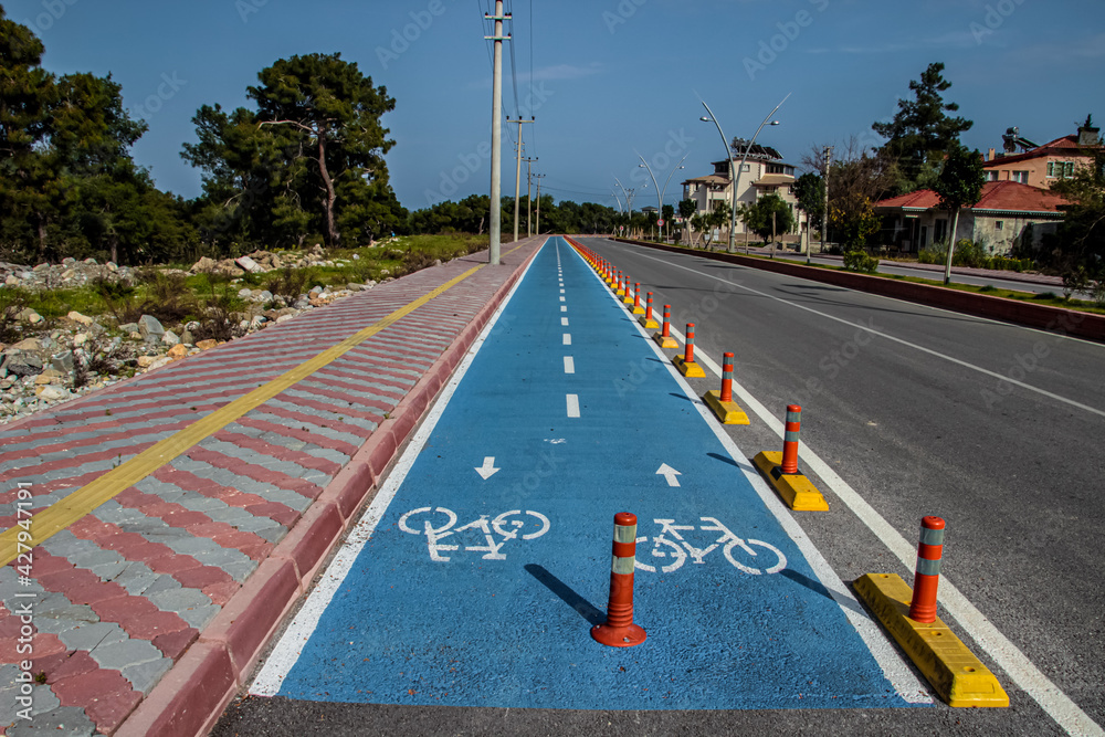 Parking lot. Blue bike path stretching into the distance against the ...