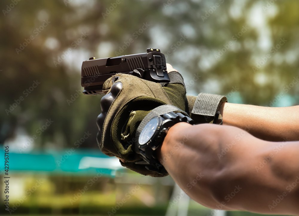 Automatic 9mm black pistol holding in hand, ready to shoot, concept for ...