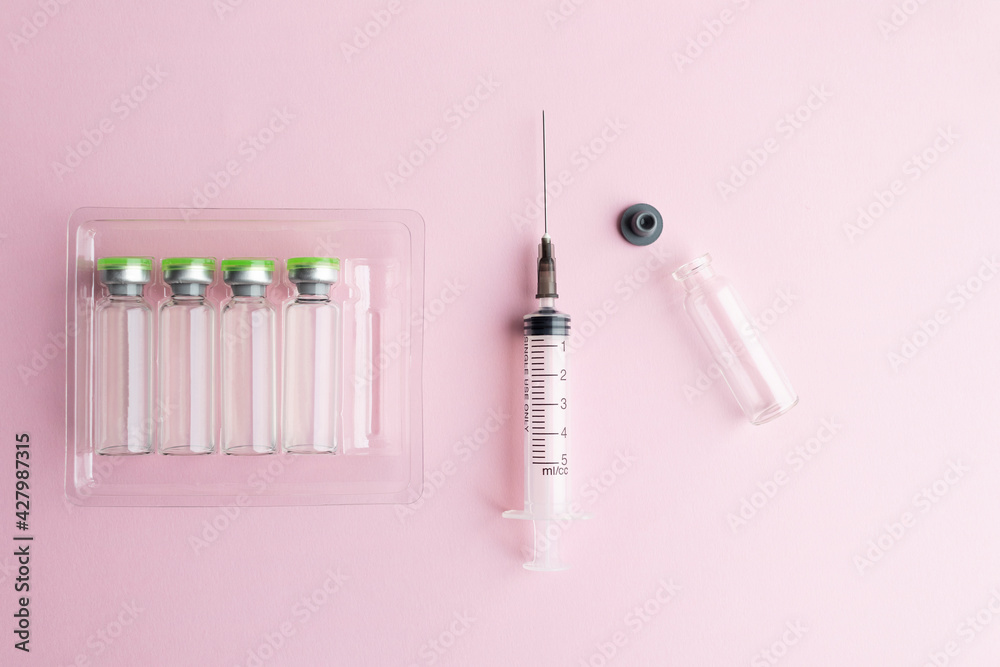 Plastic syringe with injection needle, ampoules in a container, used ...