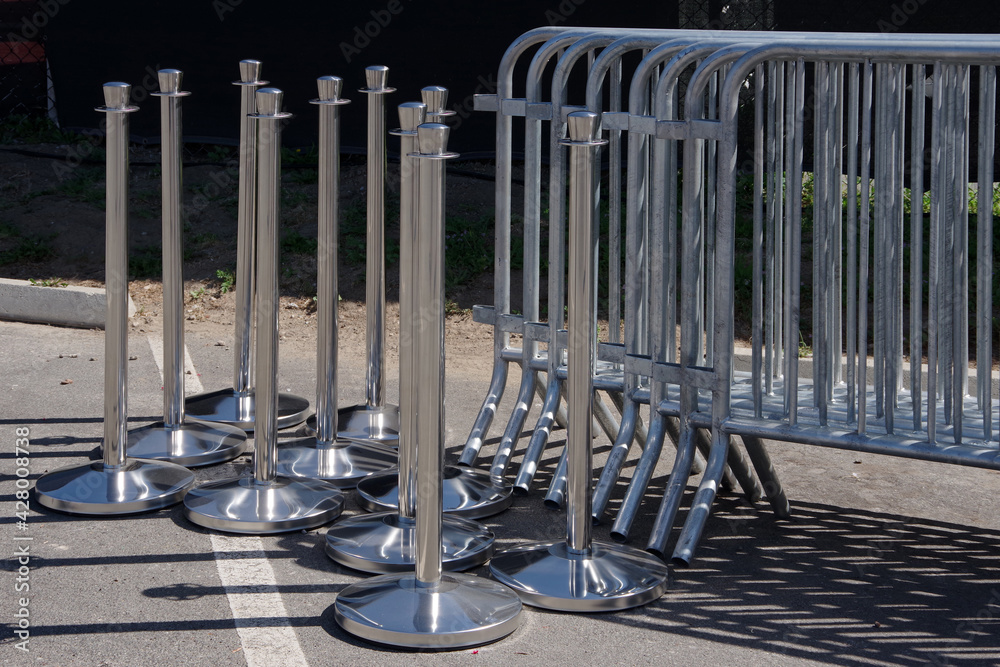 Chrome posts and metal barriers stored at the side of an event space ...