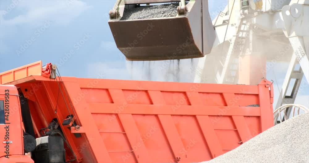 Grab is discharging bulk cargo from a hold of cargo ship, causing dust ...