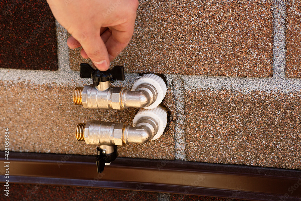 Metal ball valves for water are installed outside the house. Plumbing ...