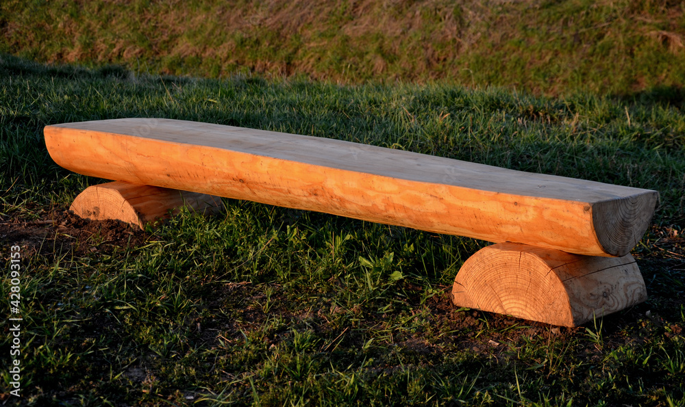 rustic bench made of halved debarked logs with legs made of logs ...