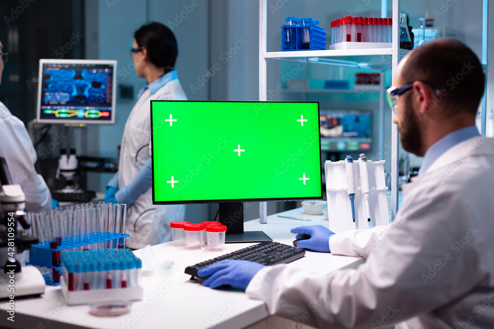 Biochemist working in laboratory using green mock-up screen chroma key ...