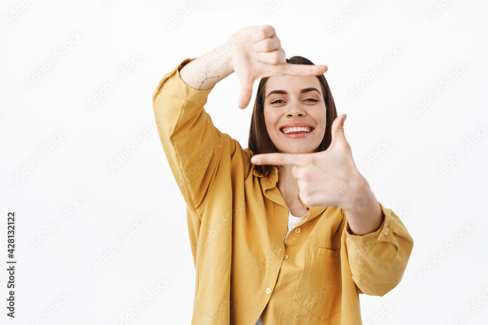 Positive creative girl making hand frames, looking through and smiling ...