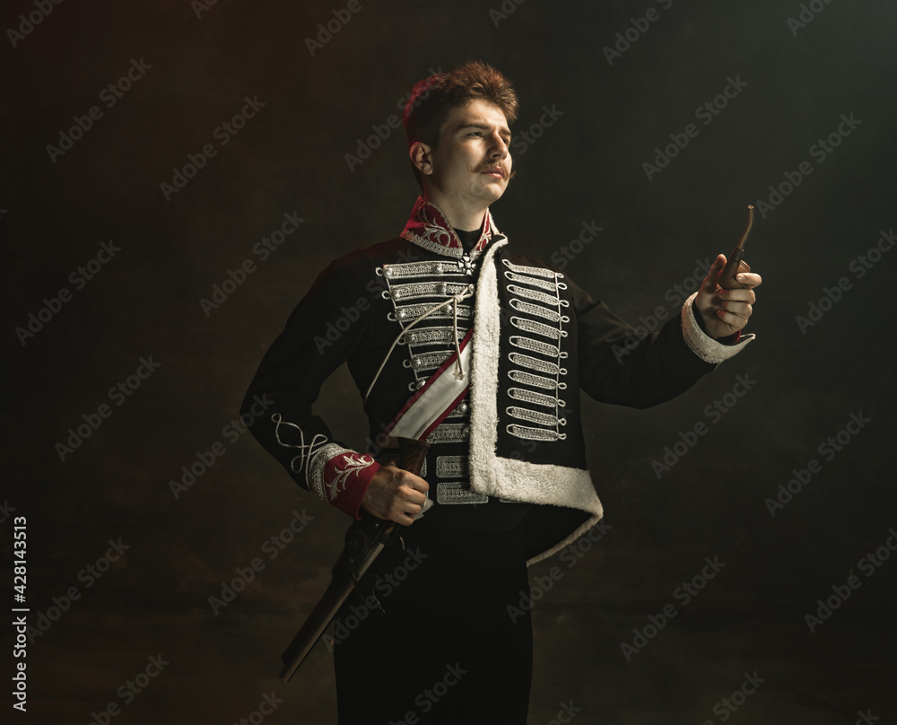 Young man in suit as royal person isolated on dark green background ...